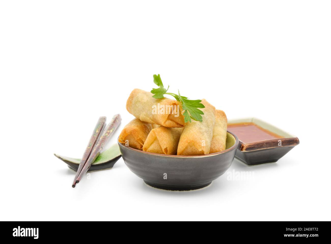 Bowl of vegetarian Thai spring rolls served with a spicy dipping sauce ...