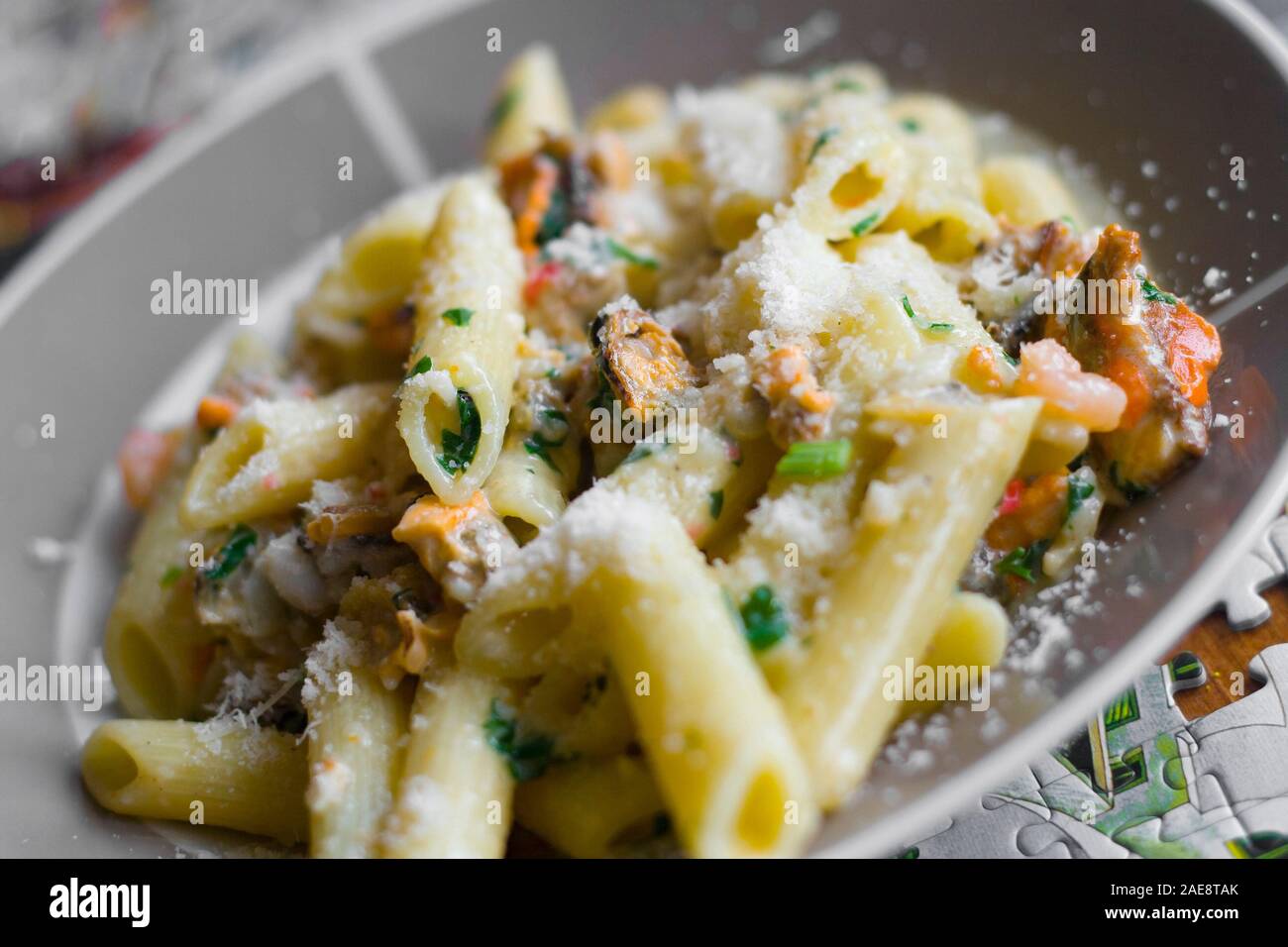 Penne pasta with seafood and parsley top sprinkled with grated parmesan ...