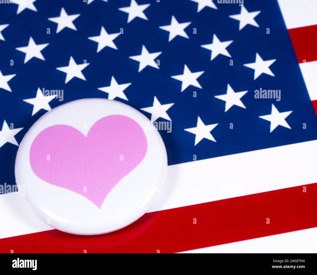 A pink heart symbol, pictured over the flag of the United States of ...