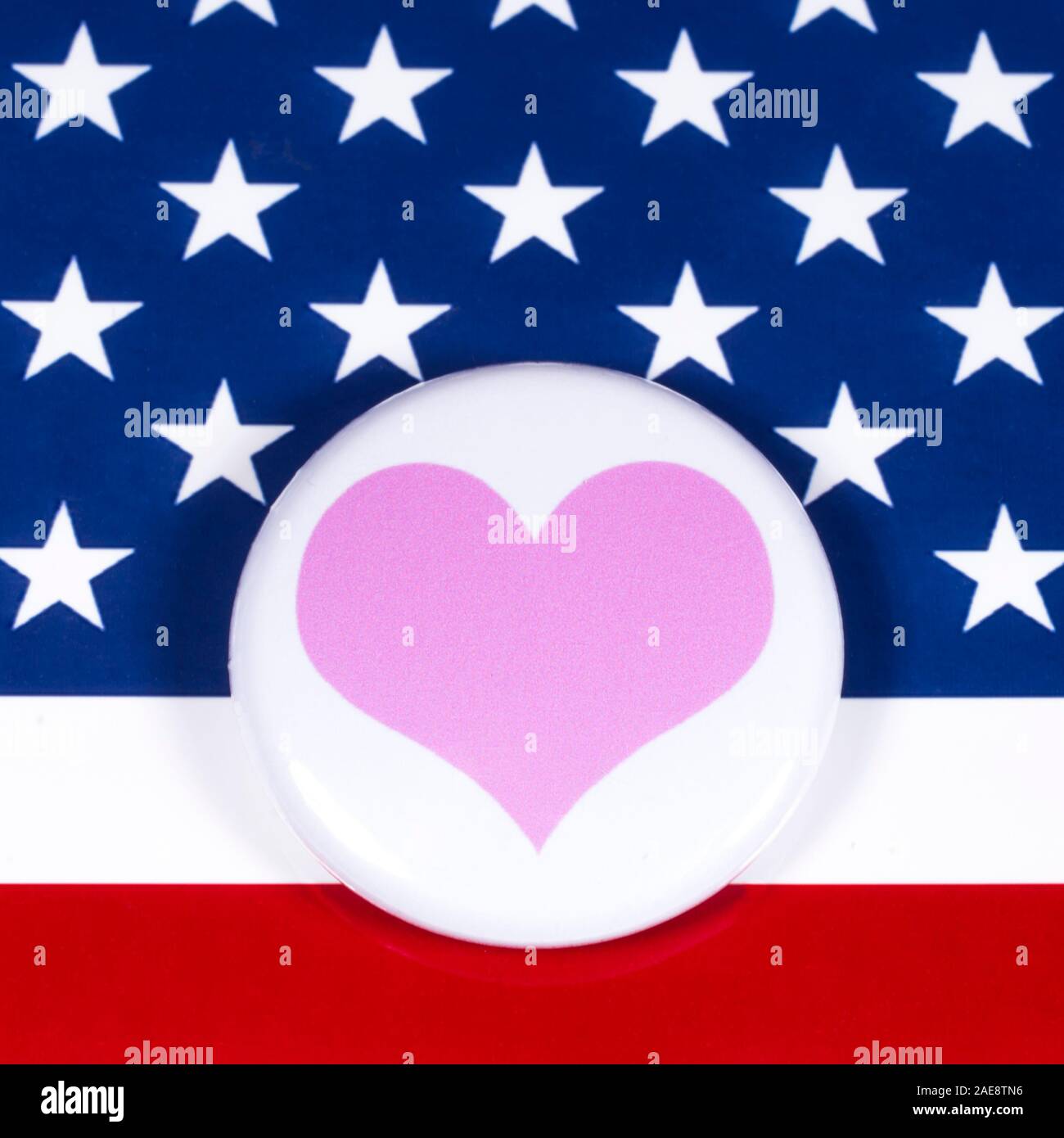 A pink heart symbol, pictured over the flag of the United States of ...