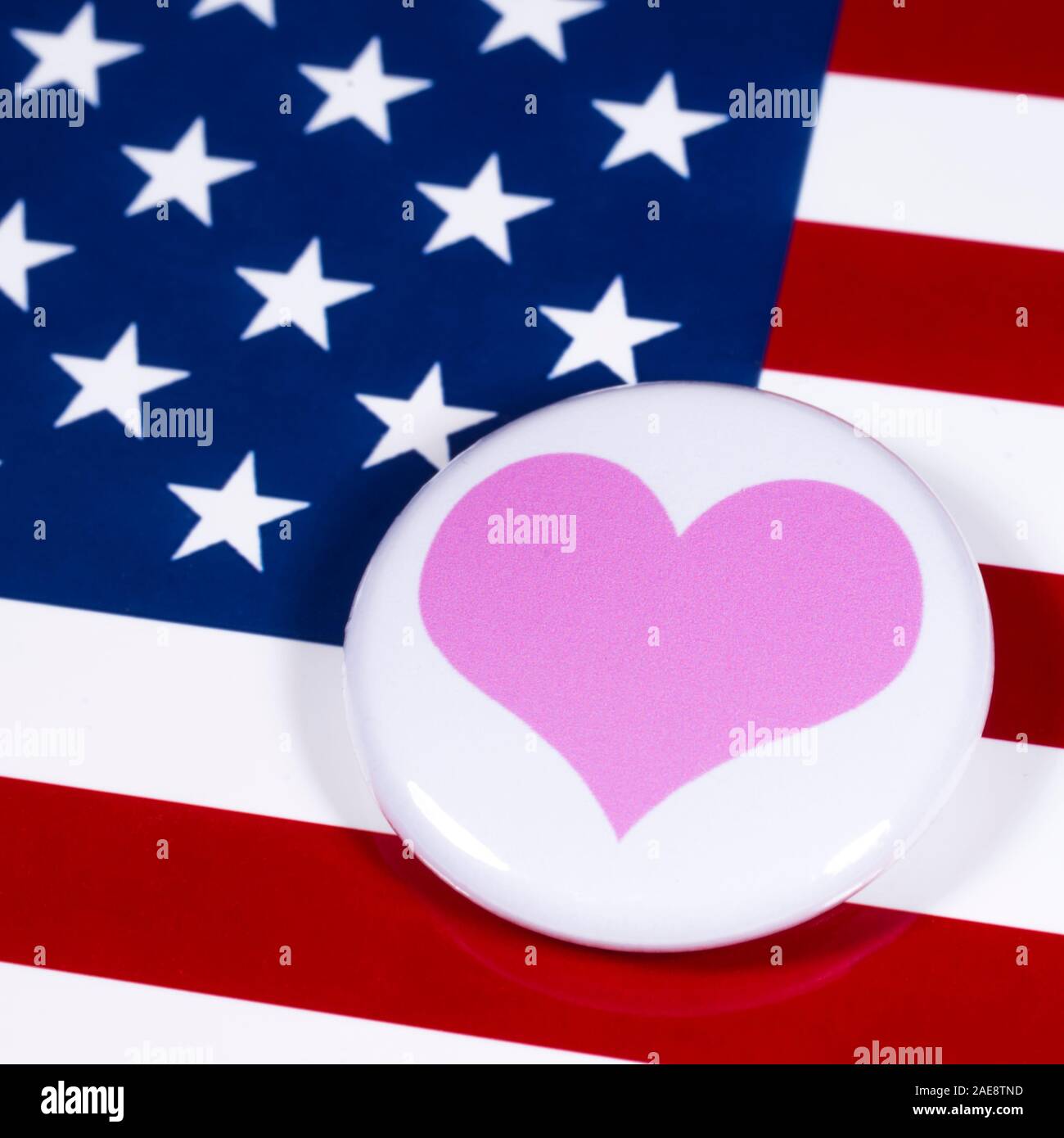 A pink heart symbol, pictured over the flag of the United States of ...