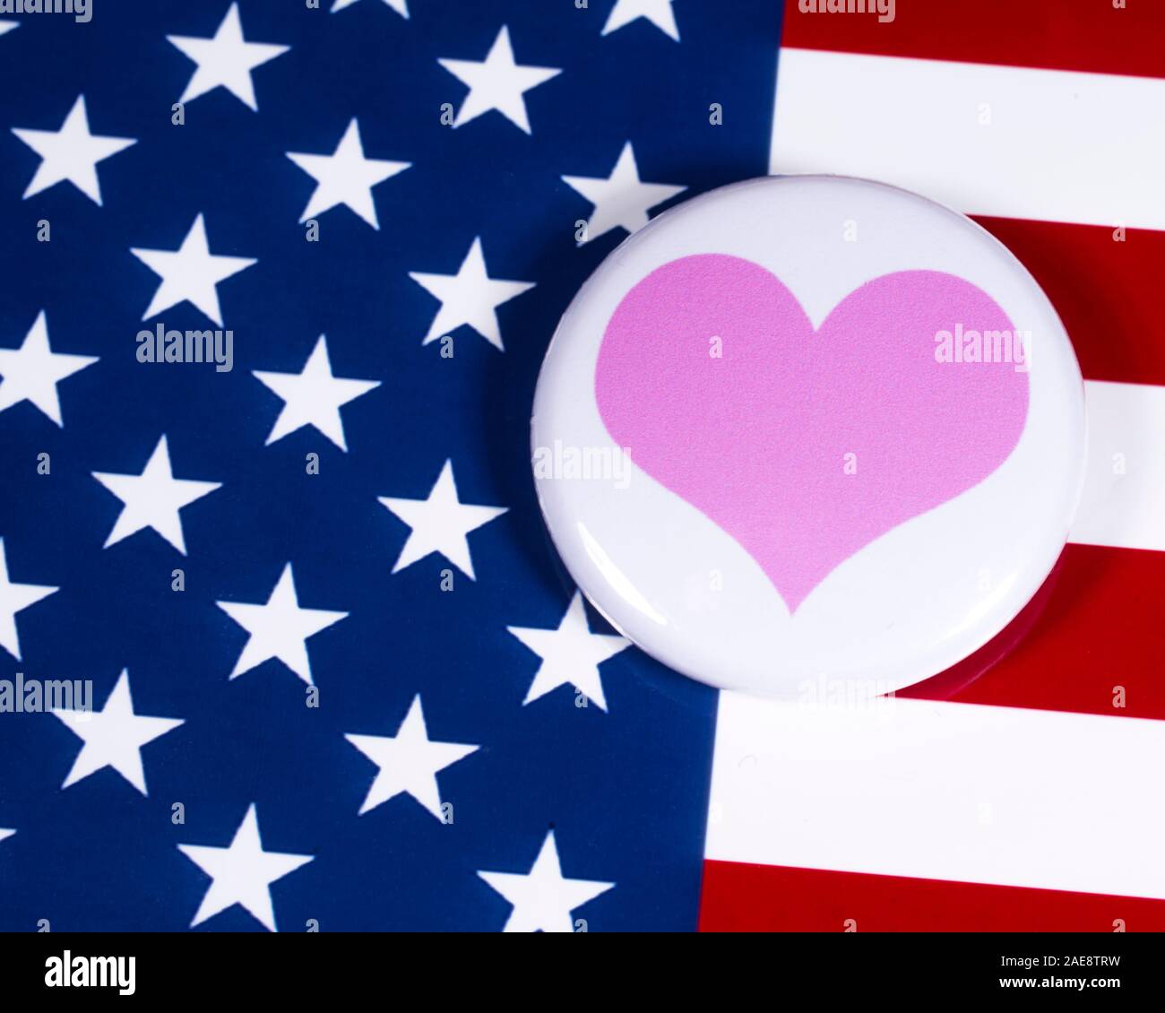 A pink heart symbol, pictured over the flag of the United States of ...