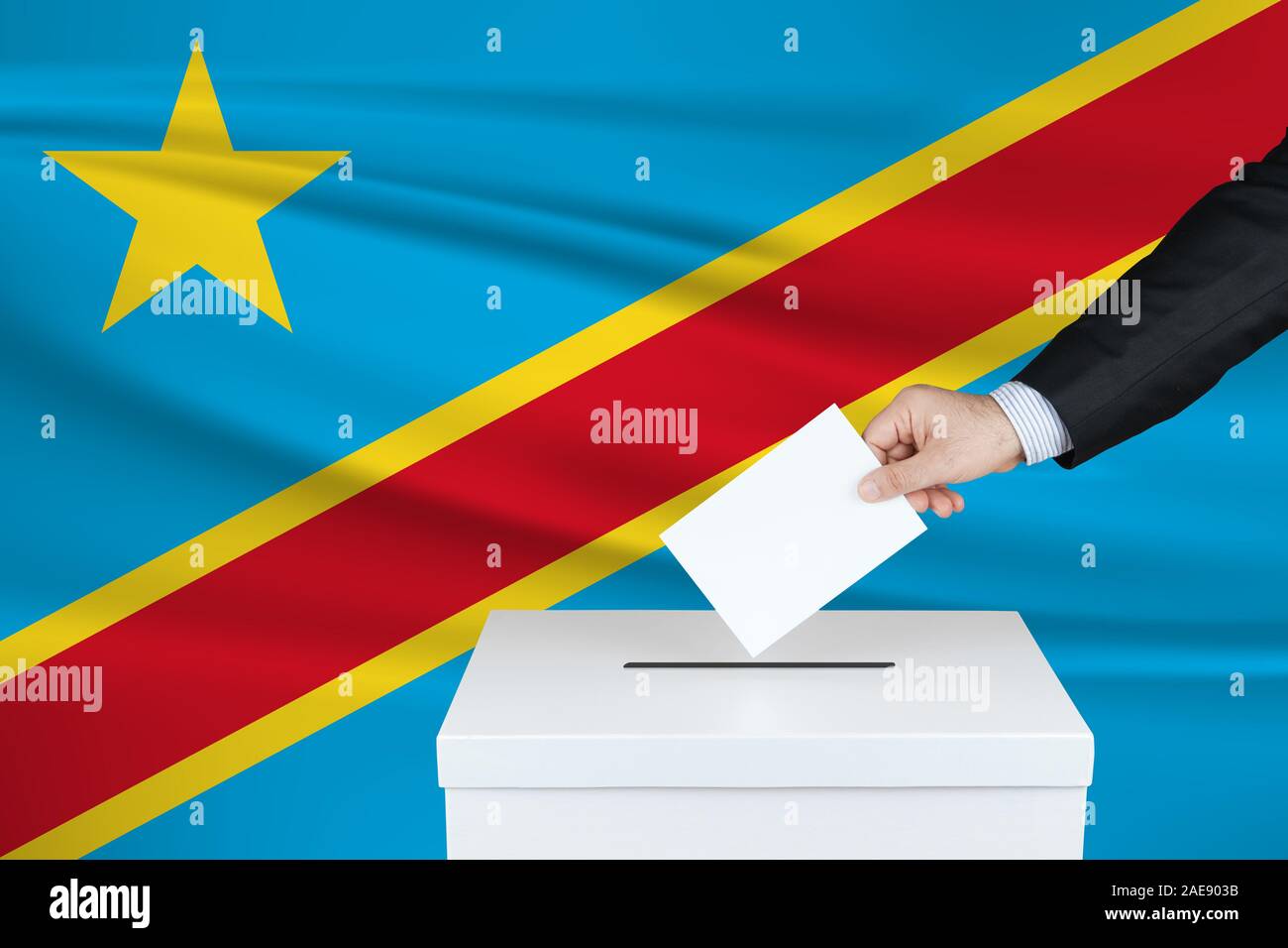 Election in Congo. The hand of man putting his vote in the ballot box ...