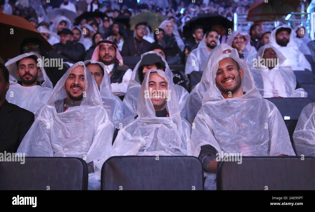 Boxing fans in the stands shelter from the rain at the Diriyah Arena ...