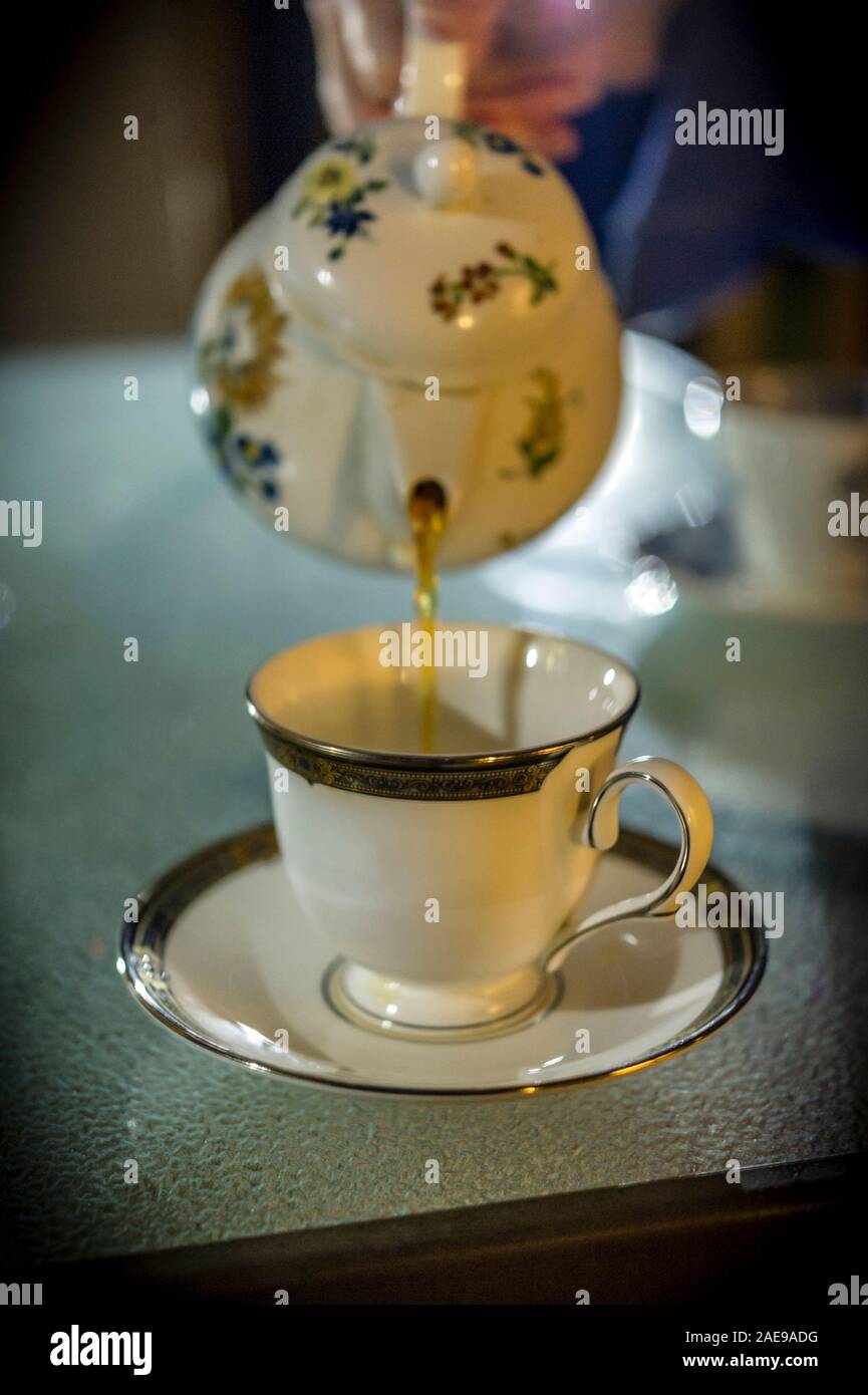 Tea pouring in a teacup from a teapot Stock Photo - Alamy