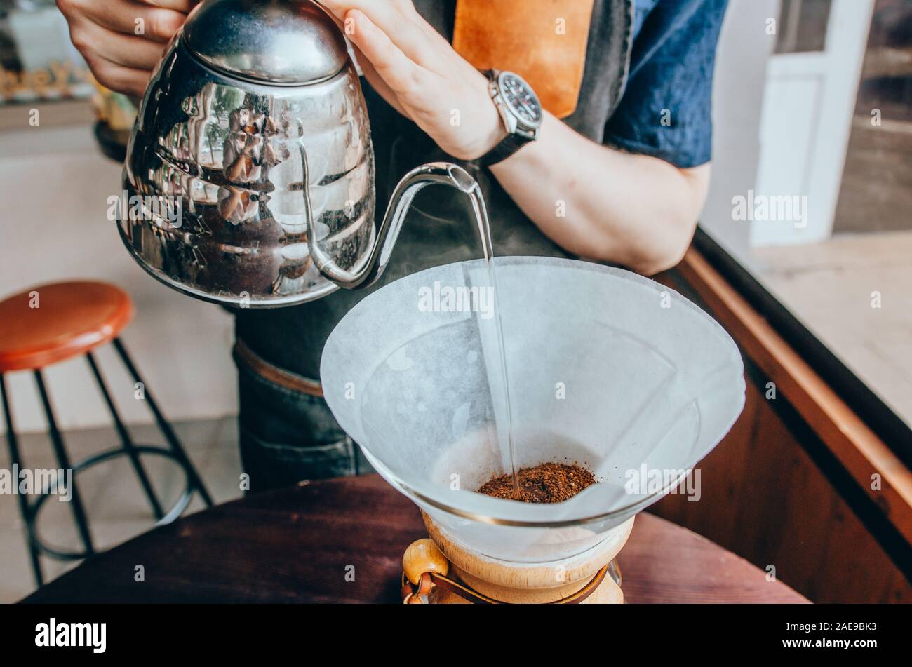 Barista preparing filter coffee outdoor. Male barista pouring boiling ...