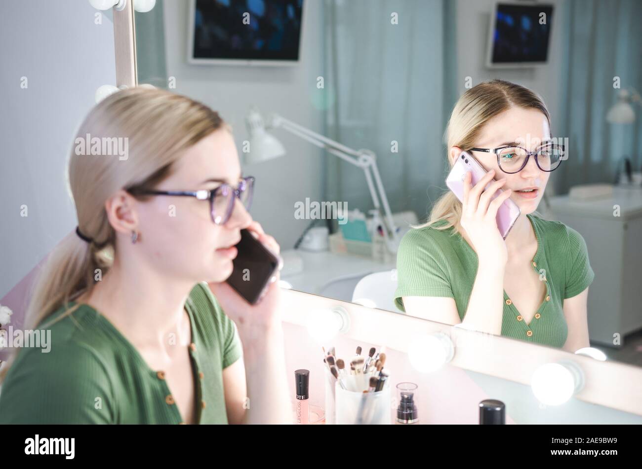Female young make up artist talks by phone with client. Professional ...