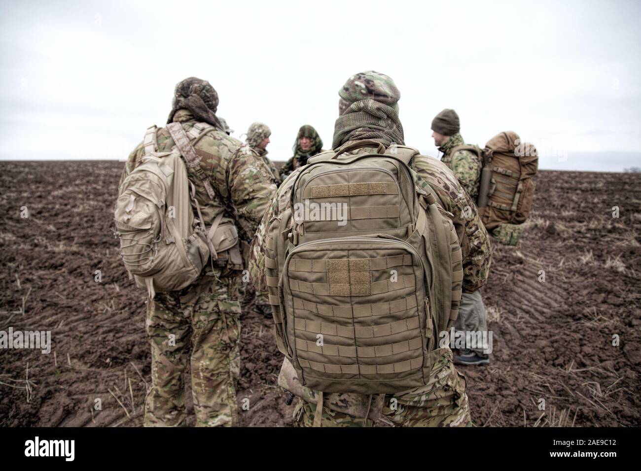 Army soldiers group on march in muddy field Stock Photo - Alamy
