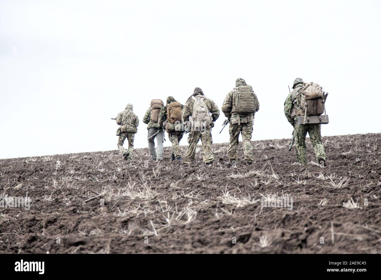 Army soldiers group on march in muddy field Stock Photo - Alamy