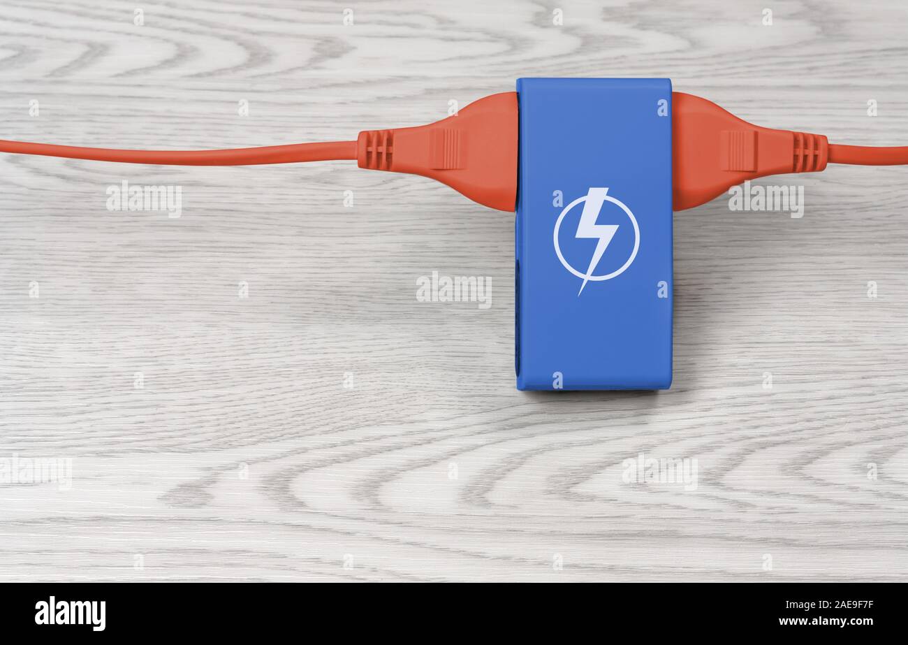 Two orange cables connected to a blue multiple socket over a light wood ...