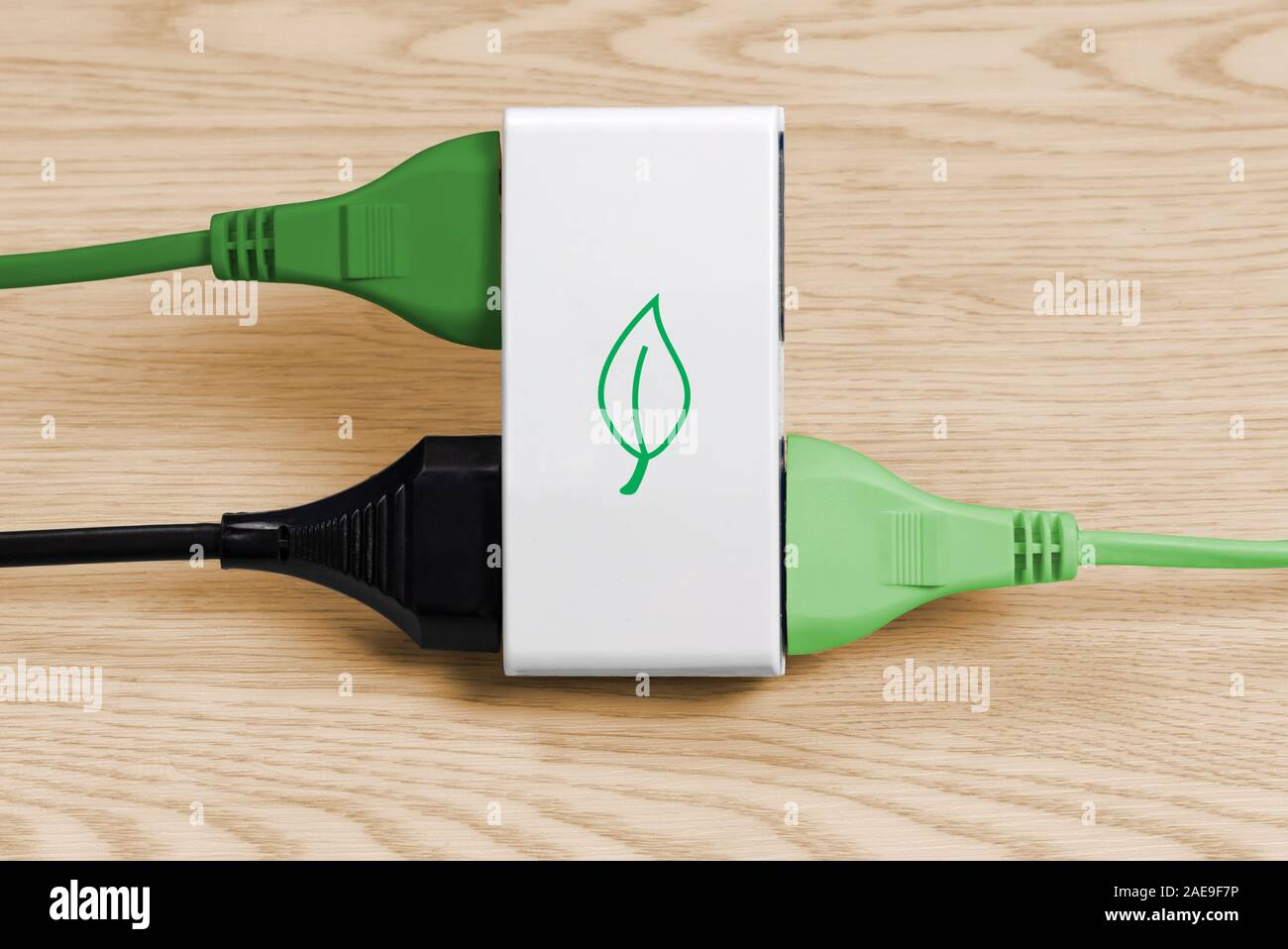 Two green cables and a black one connected to a multiple socket over a ...