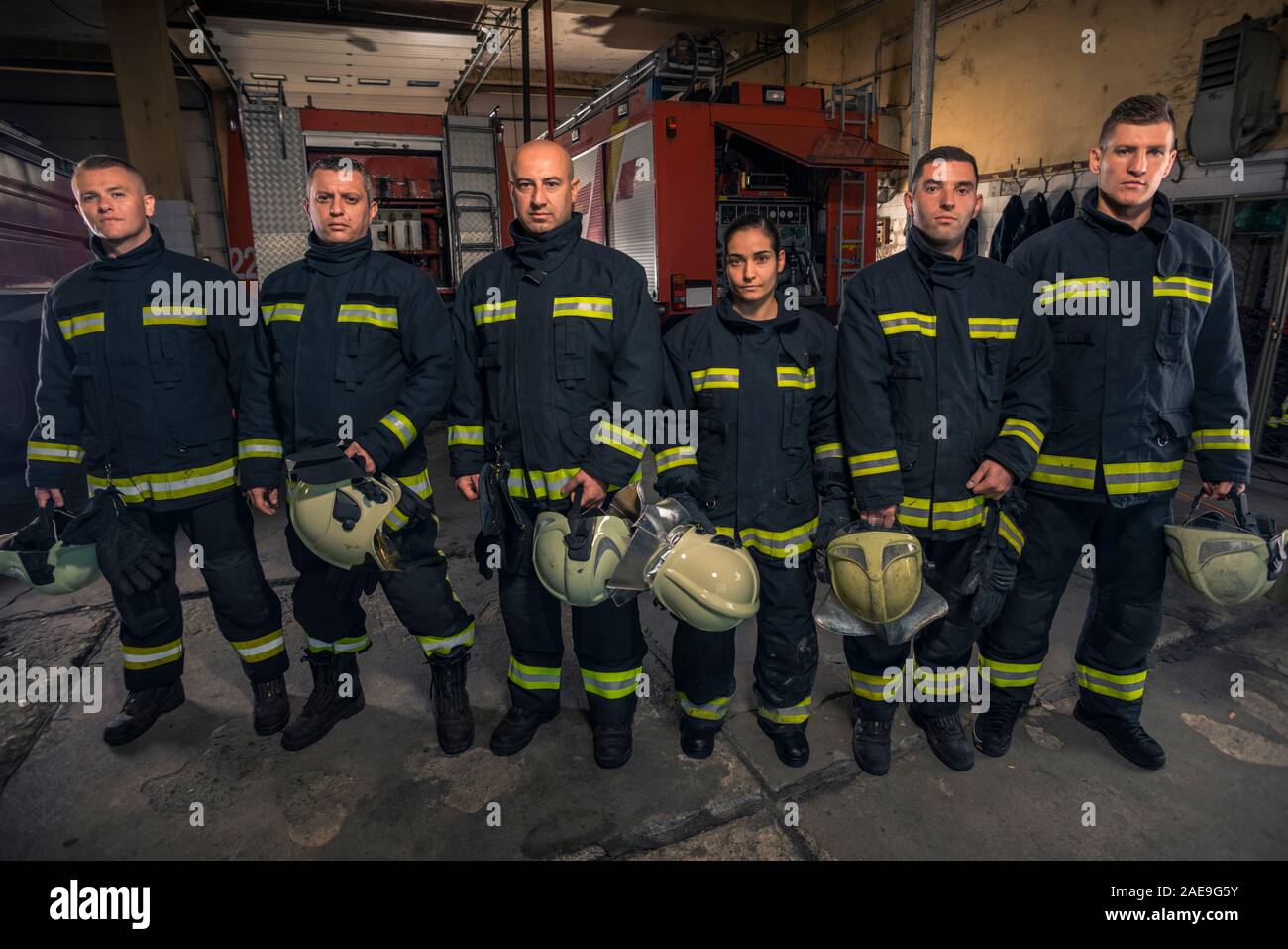 Portrait of firefighters standing by a fire engine Stock Photo - Alamy