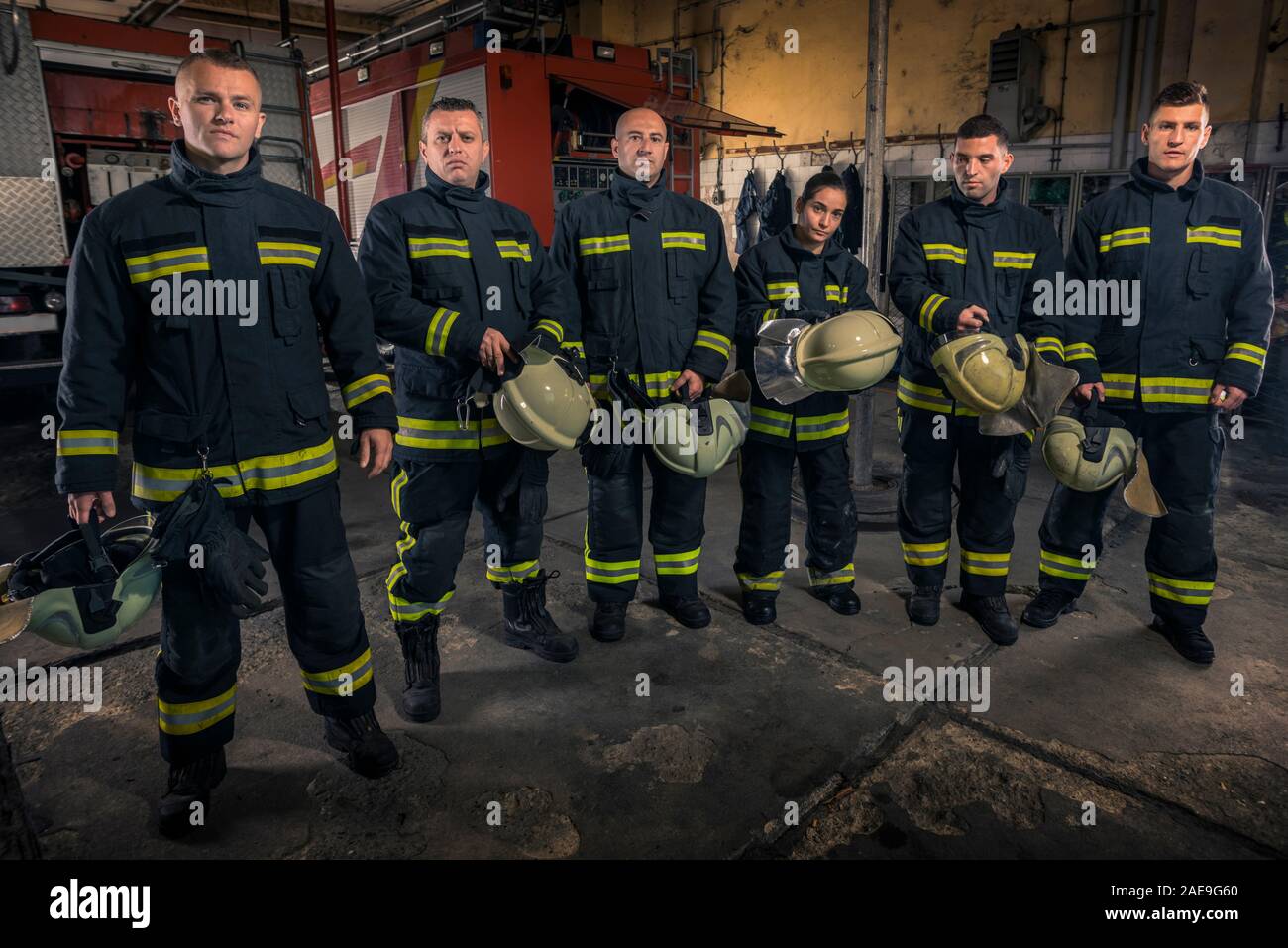 Portrait of firefighters standing by a fire engine Stock Photo - Alamy