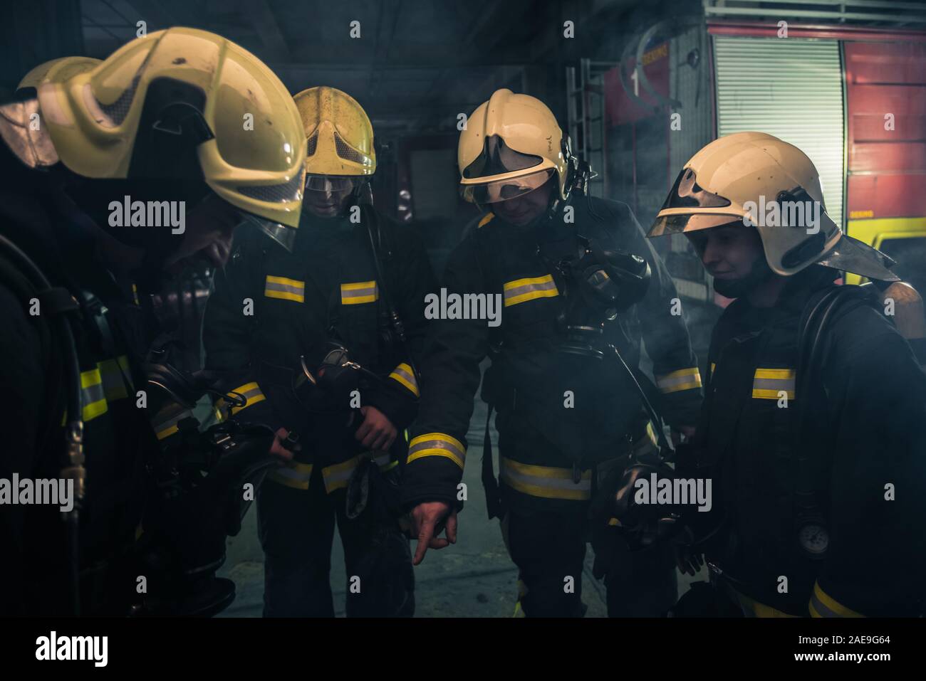 Team of firefighters standing inside ( indoors ) a buliding next to a ...