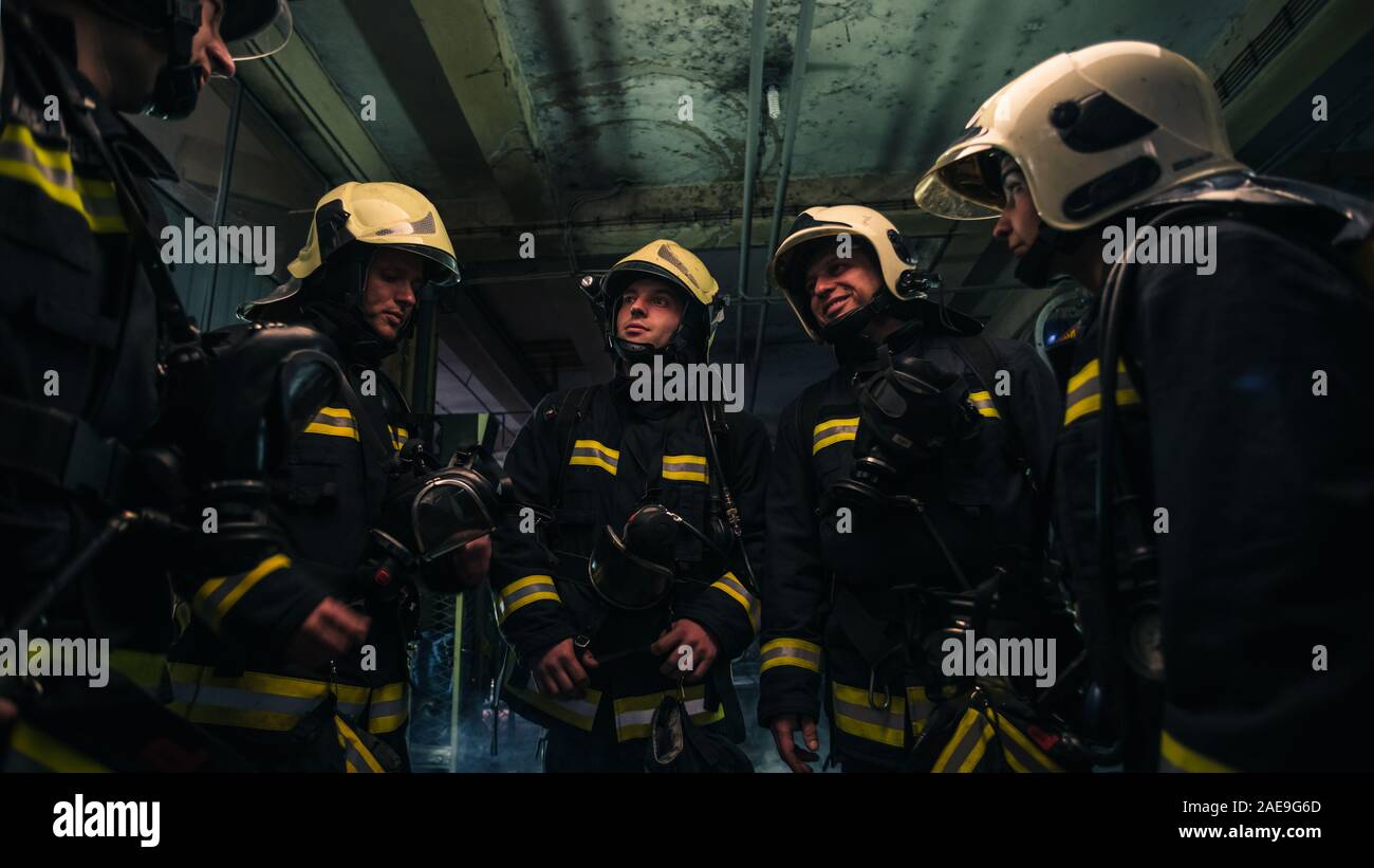 Team of firefighters standing inside ( indoors ) a buliding next to a ...