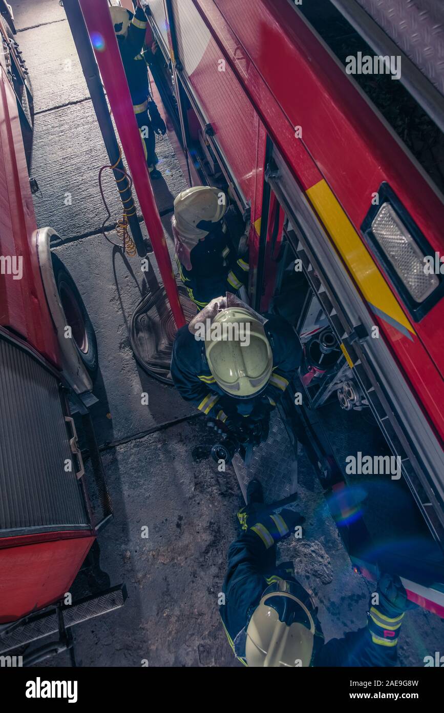 Firemen checking the fire engine inside the fire department from a bird ...