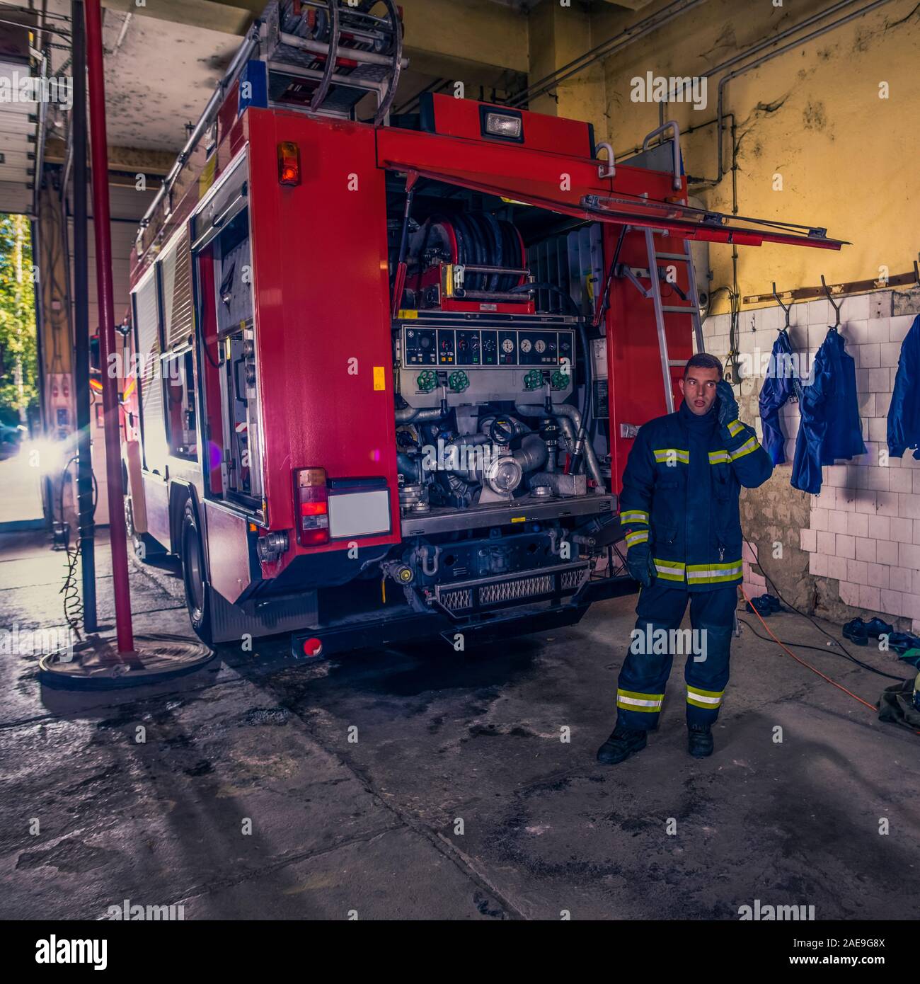 A firefighter repairing the fire engine in the fire station Stock Photo ...