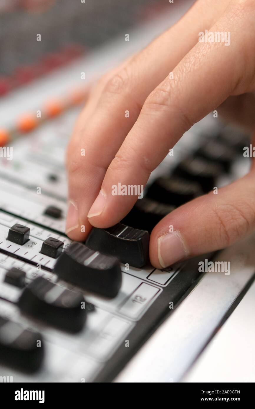 Male hand on control Fader on console. Sound recording studio mixing ...