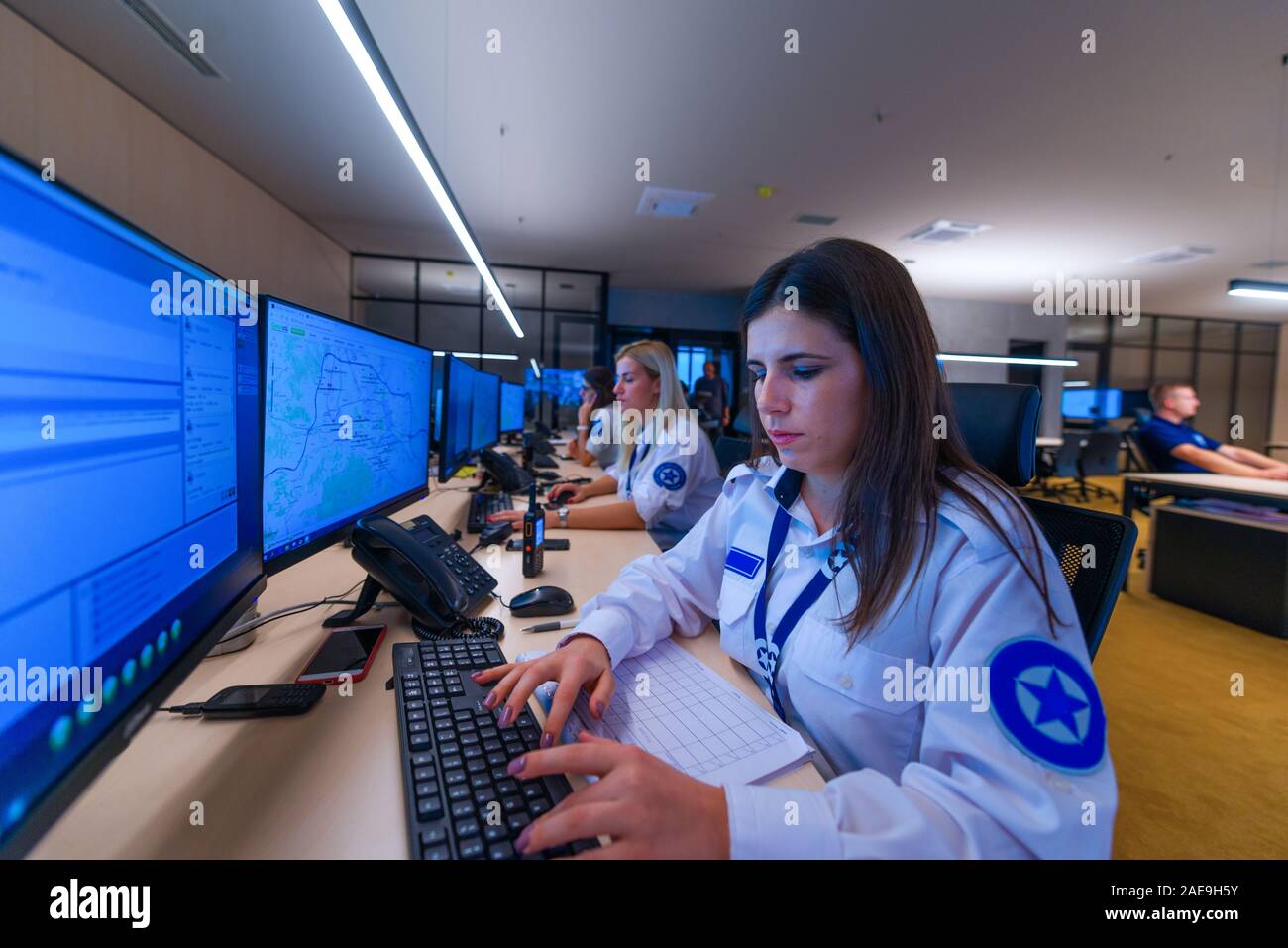 Female security operator working in a security data control room ...