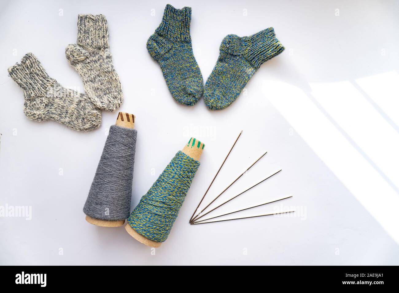 Socks, thread, needles are on white background Stock Photo - Alamy