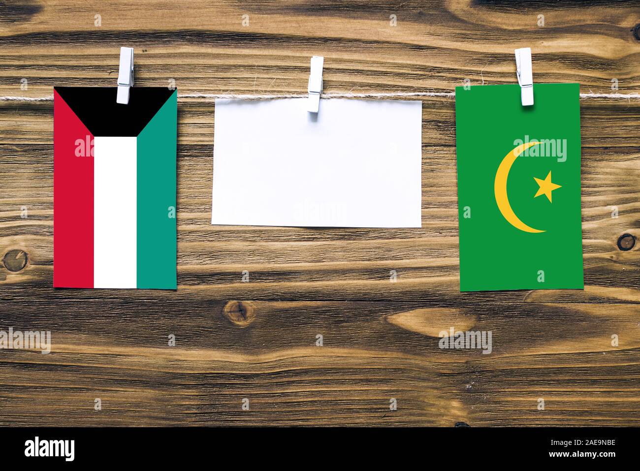 Hanging flags of Kuwait and Mauritania attached to rope with clothes ...
