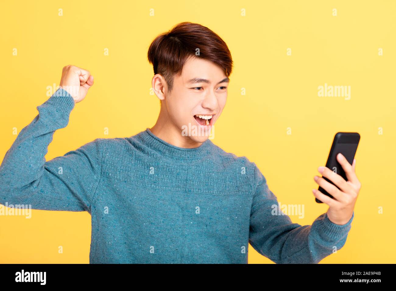 Excited man holding smartphone hi-res stock photography and images - Alamy