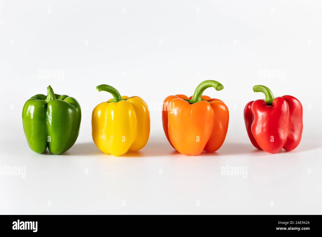 Colored bell peppers on white background. Green, yellow, orange and red ...