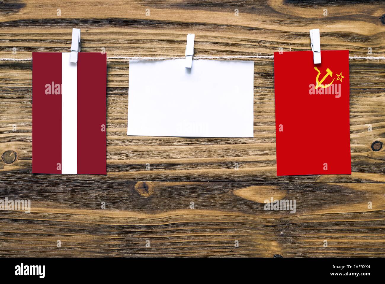 Hanging flags of Latvia and Soviet Union attached to rope with clothes ...