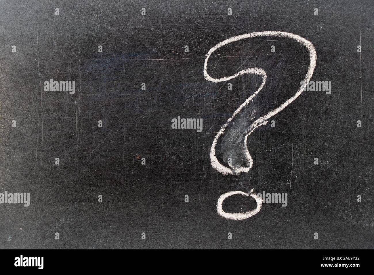 White color chalk hand drawing in question mark shape on blackboard ...