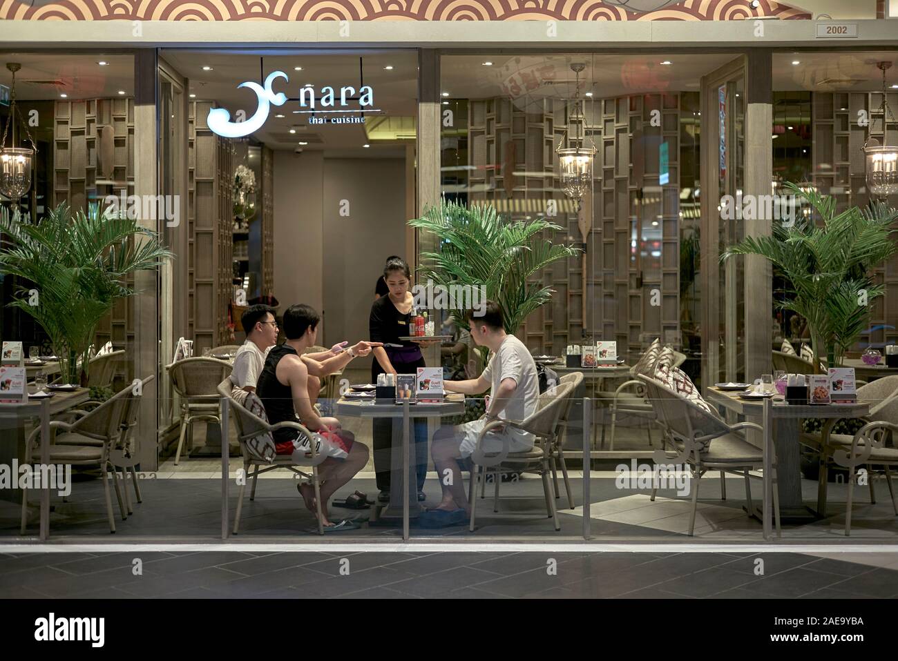 Thailand restaurant exterior with customers dining outside and waitress ...