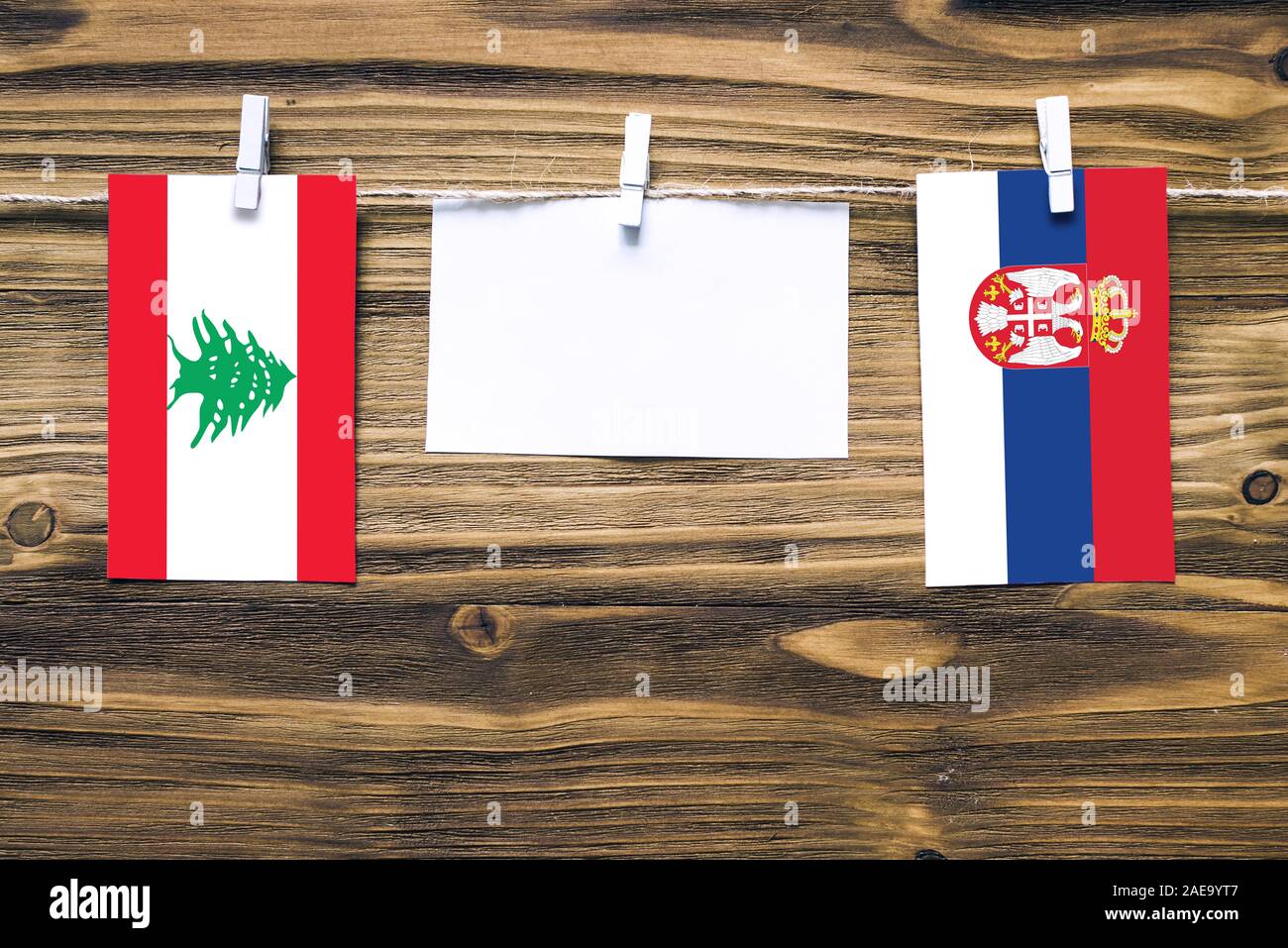 Hanging flags of Lebanon and Serbia attached to rope with clothes pins ...