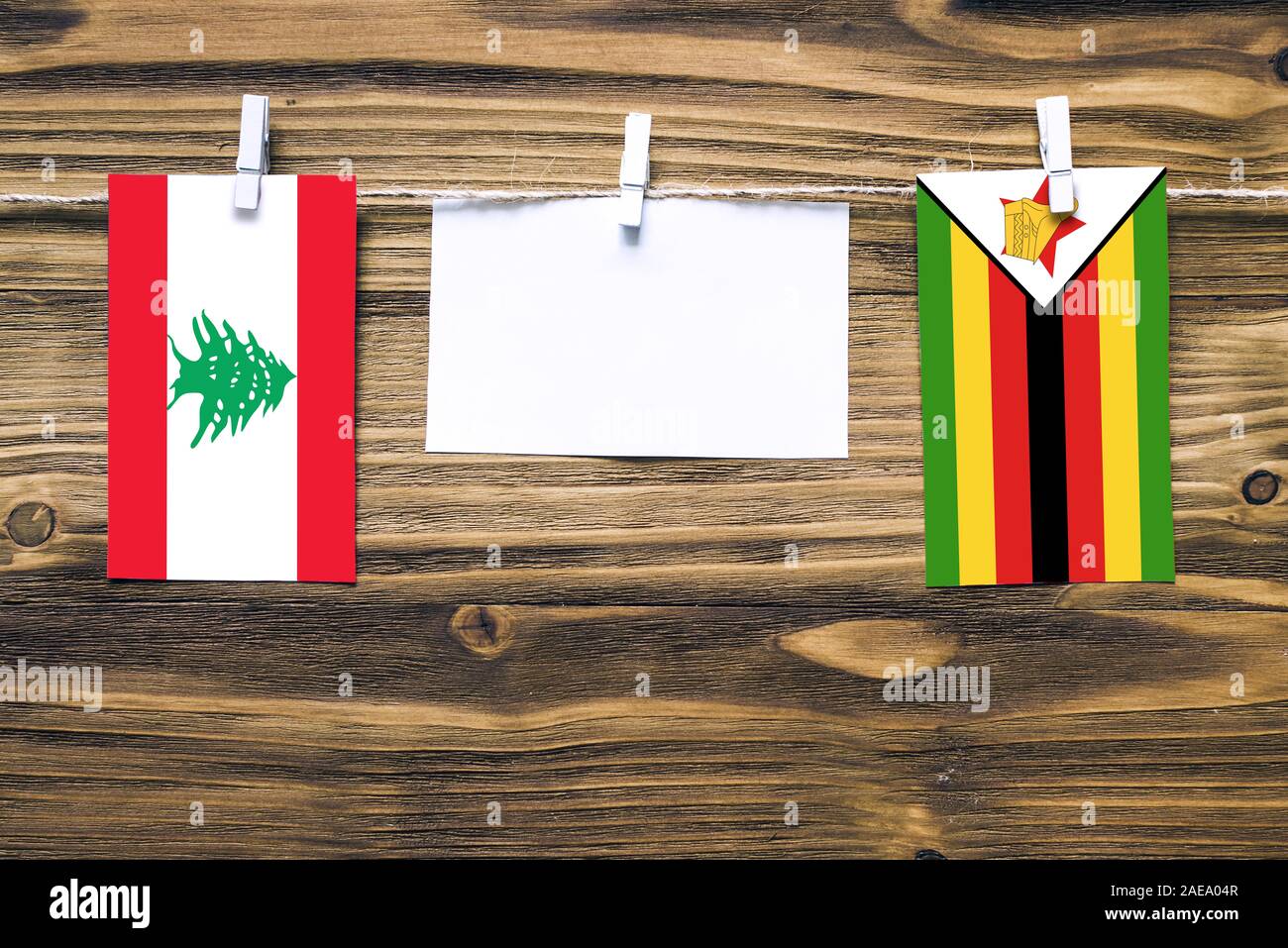 Hanging flags of Lebanon and Zimbabwe attached to rope with clothes ...
