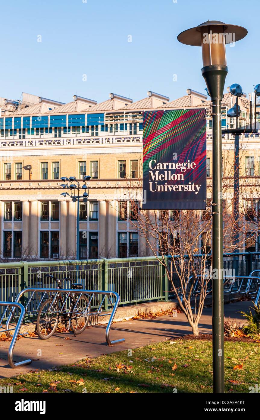 A Carnegie Mellon University sign in front of a bike rack with parked ...