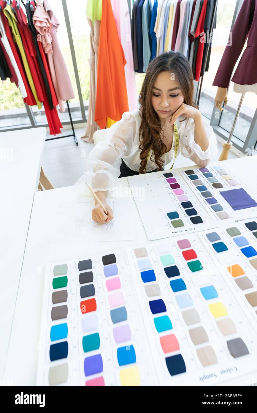 Wide angle view a young adult fashion designer drawing and sketching ...