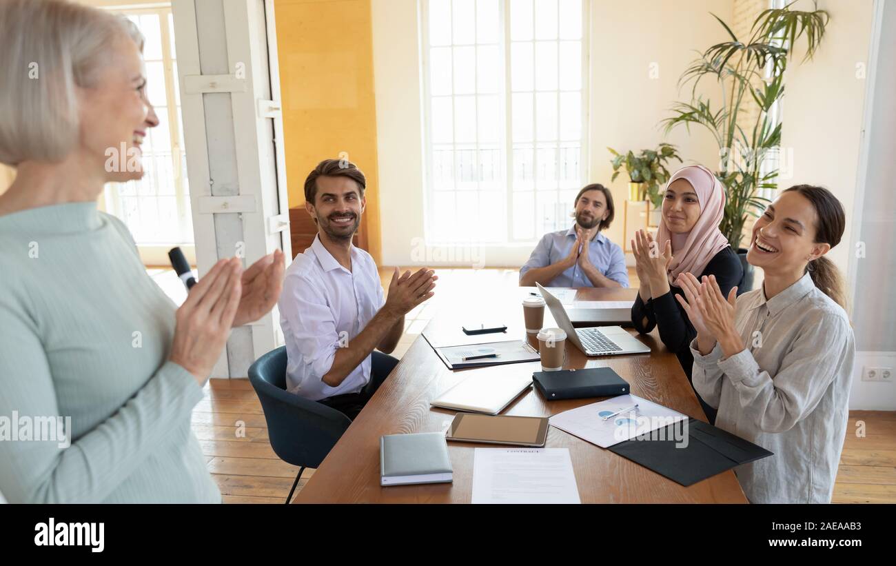 Happy mixed race colleagues clapping hands, celebrating good project ...