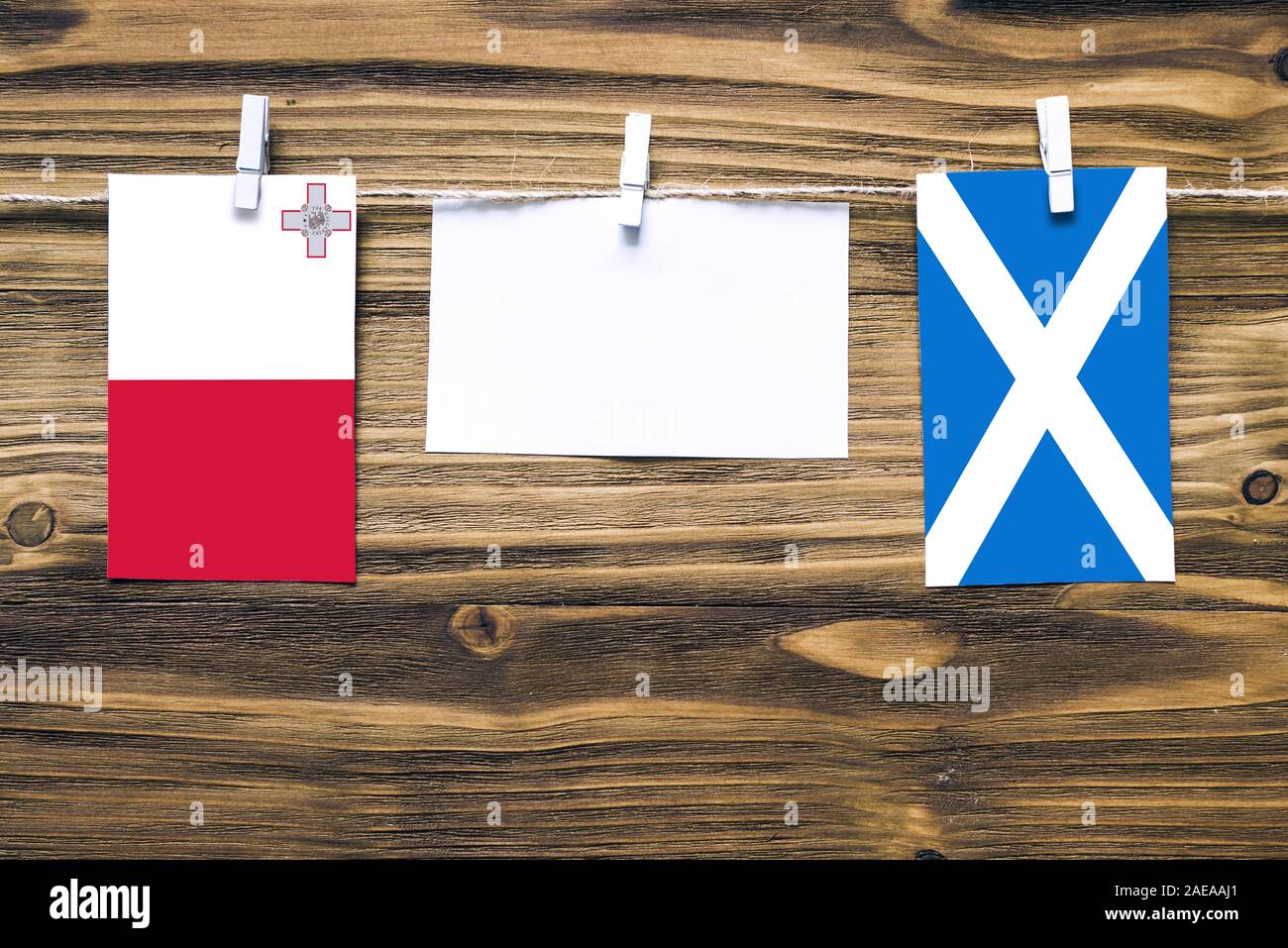 Hanging flags of Malta and Scotland attached to rope with clothes pins ...