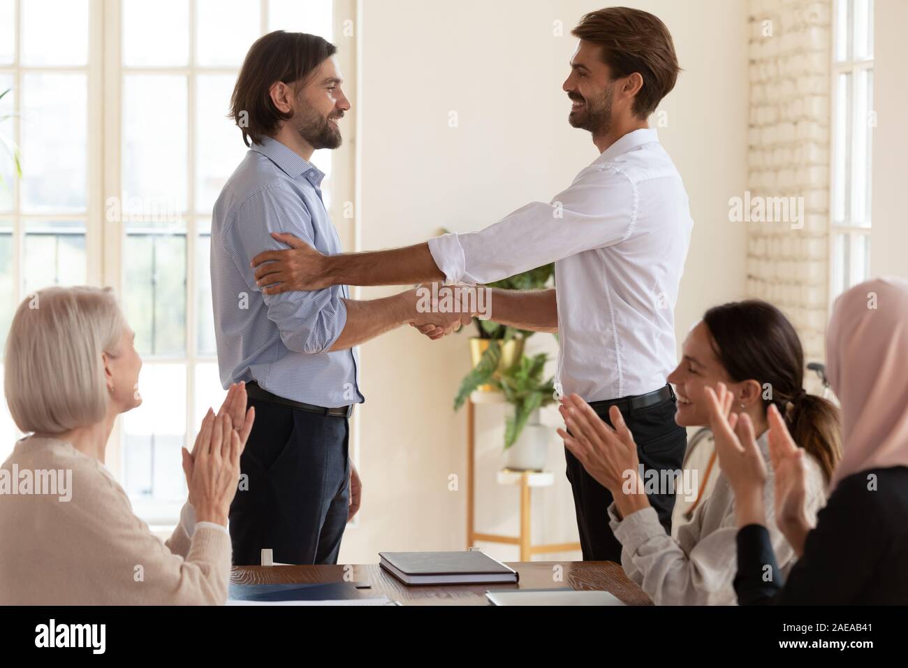Smiling boss shaking hands with happy male coworker Stock Photo - Alamy