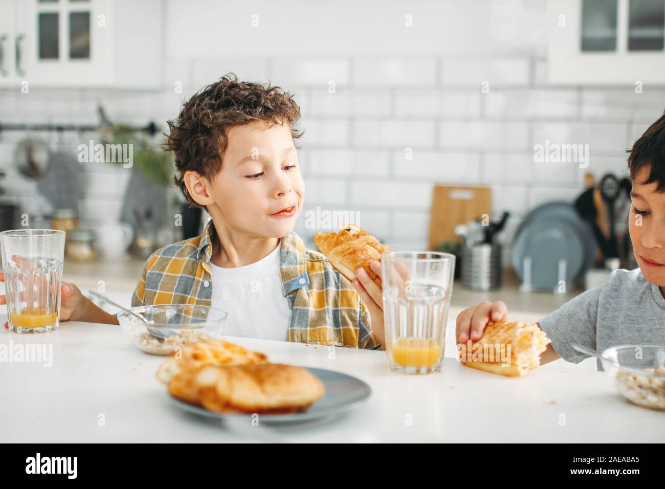 Two siblings tween boys real brothers having breakfast on bright ...