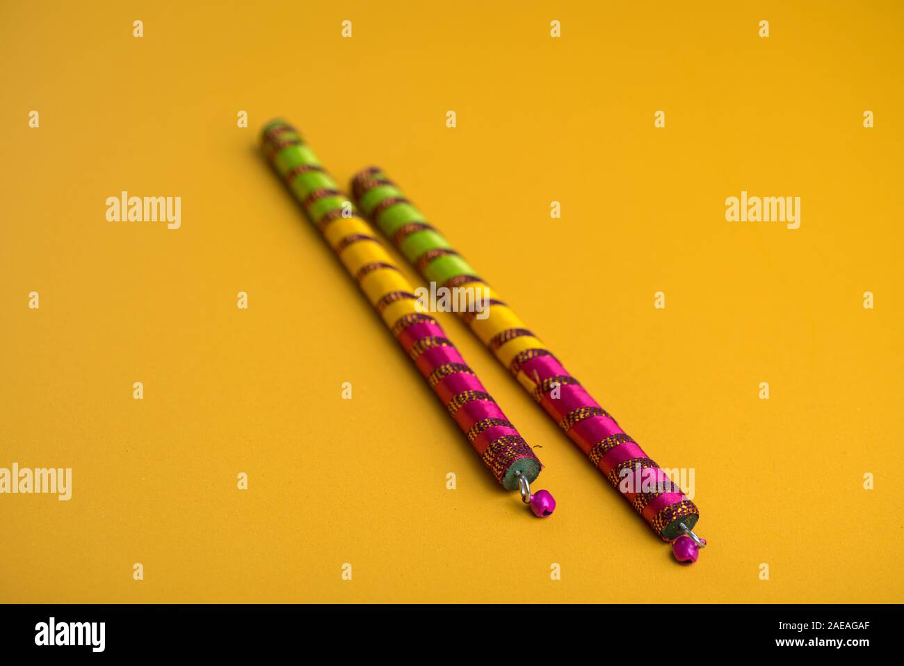 Dandiya sticks on a yellow background. Raas Garba or Dandiya Raas is ...
