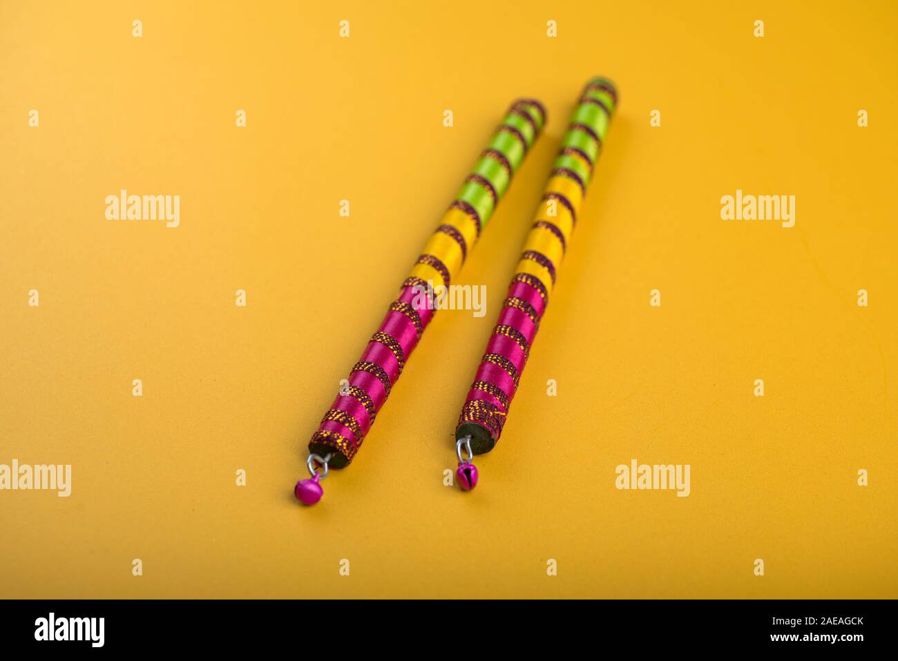 Dandiya sticks on a yellow background. Raas Garba or Dandiya Raas is ...