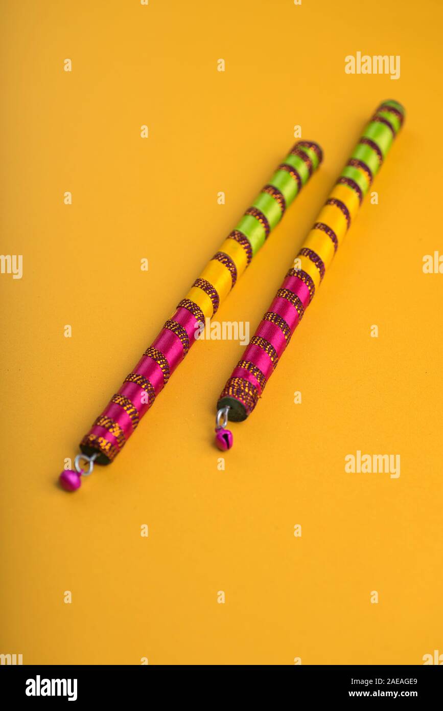 Dandiya sticks on a yellow background. Raas Garba or Dandiya Raas is ...