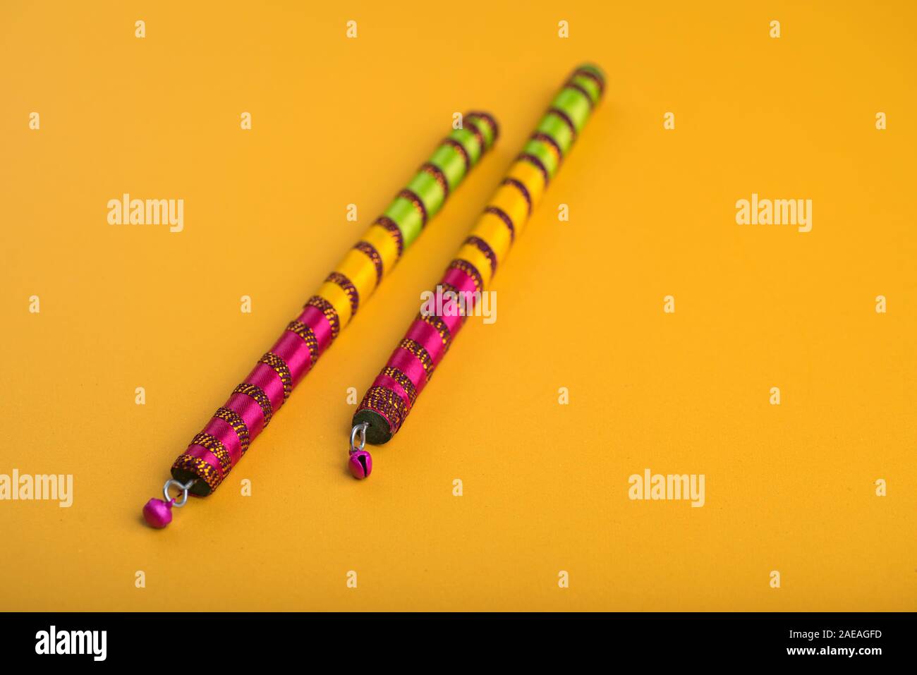 Dandiya sticks on a yellow background. Raas Garba or Dandiya Raas is ...