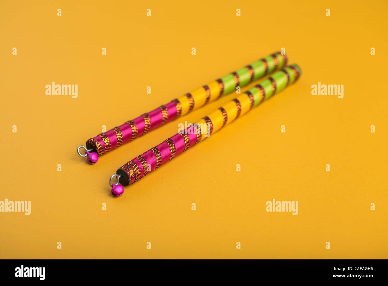 Dandiya sticks on a yellow background. Raas Garba or Dandiya Raas is ...