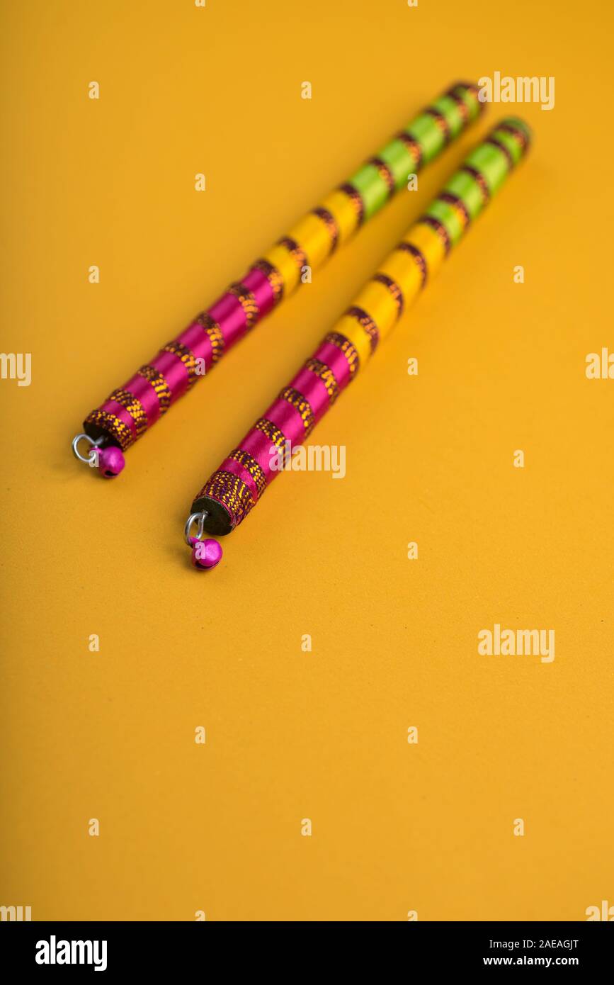 Dandiya sticks on a yellow background. Raas Garba or Dandiya Raas is ...