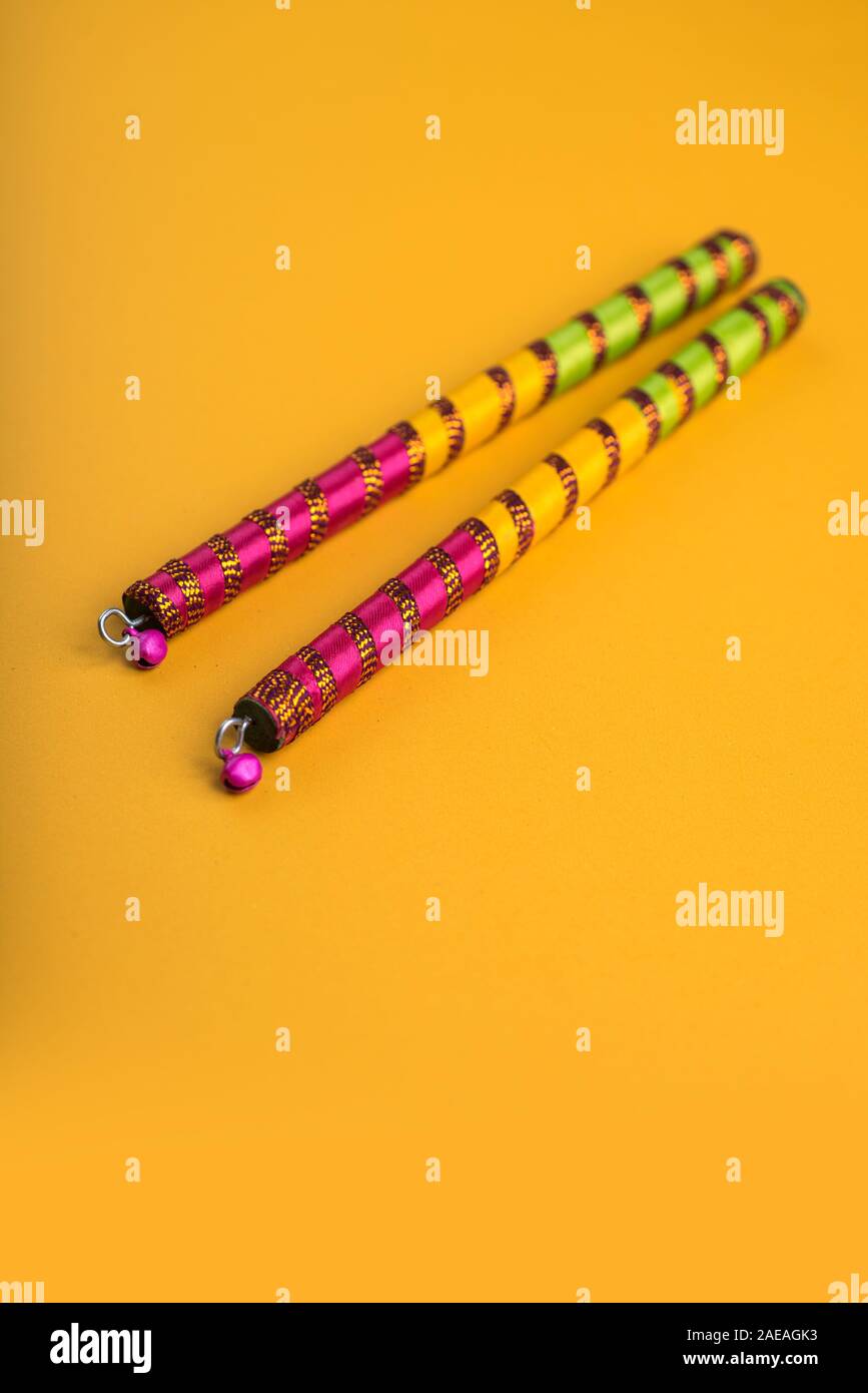 Dandiya sticks on a yellow background. Raas Garba or Dandiya Raas is ...