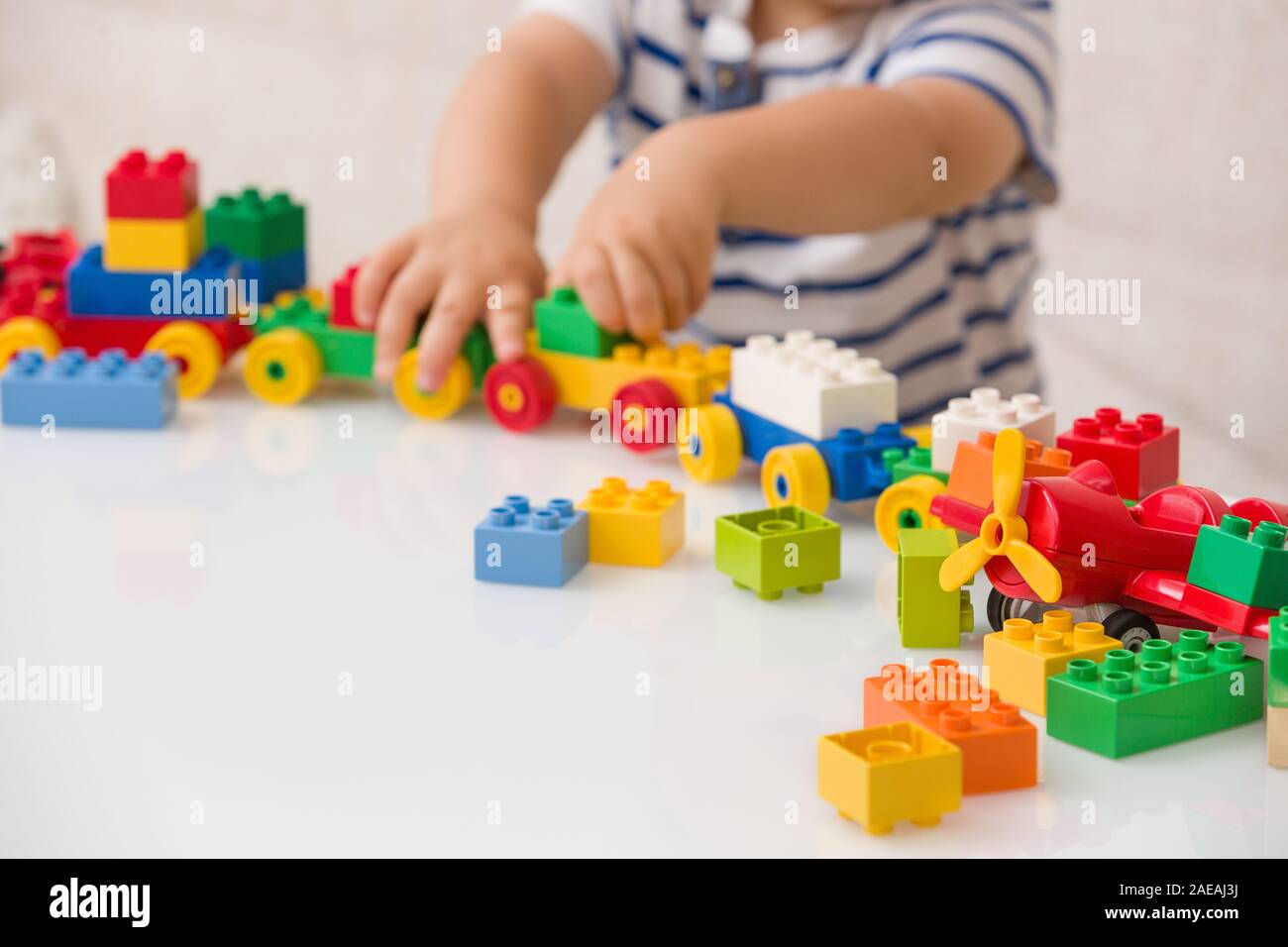 Close up of child's hands playing with colorful plastic bricks at the ...