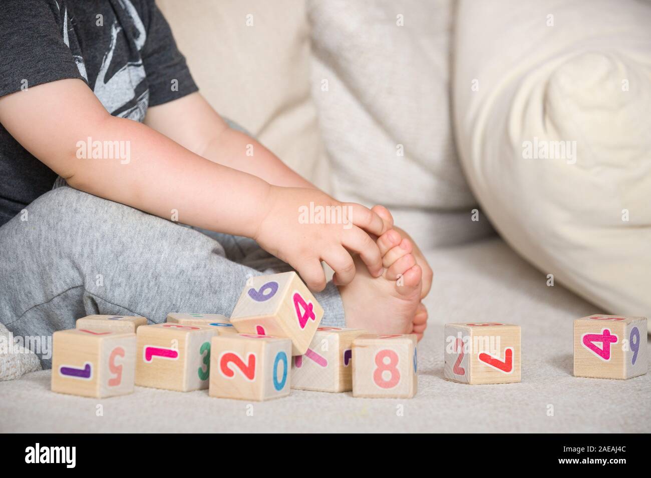 Child playing with wooden cubes with numbers. Toddler learning numbers ...