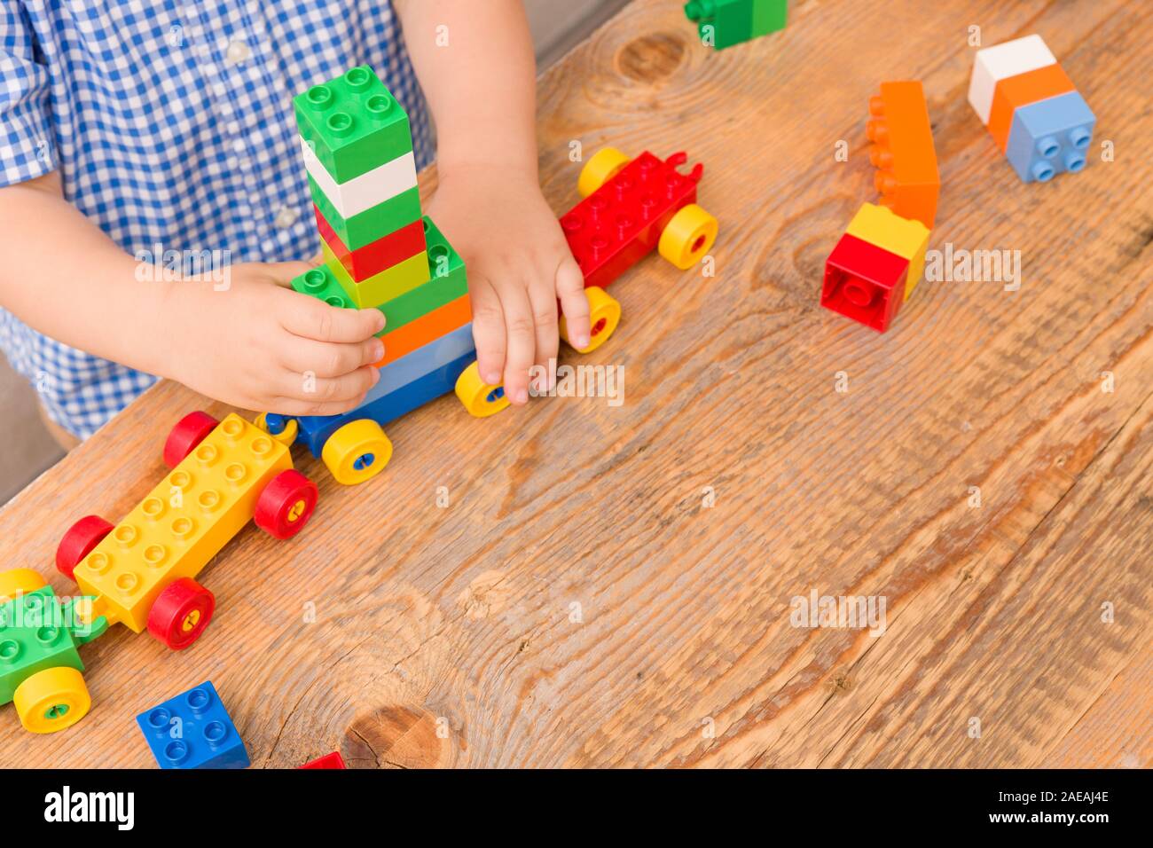 Close up of child's hands playing with colorful plastic bricks at the ...