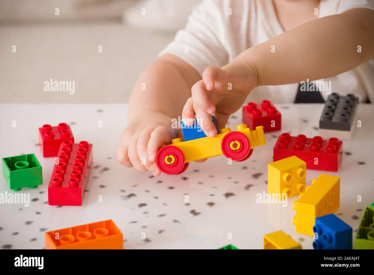 Close up of child's hands playing with colorful plastic bricks at the ...