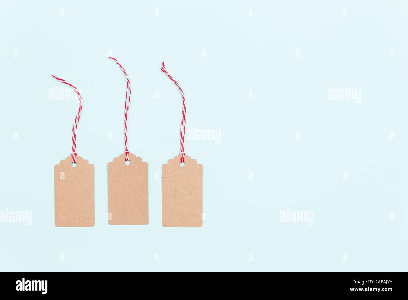 christmas tags in plain cardboard with red string and white string on ...